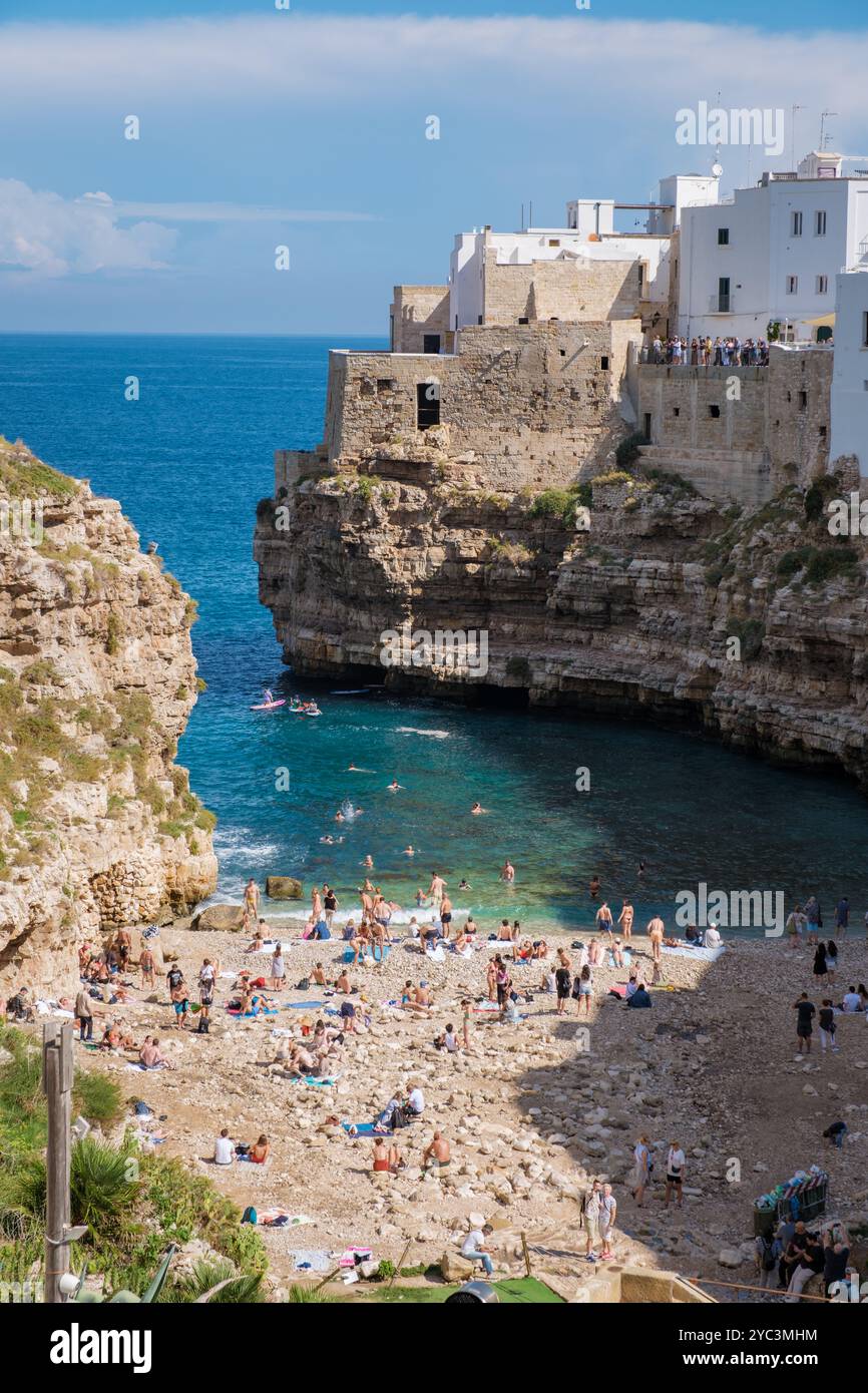 Polignano a Mare Visitors bask in the summer sun at a picturesque cove ...