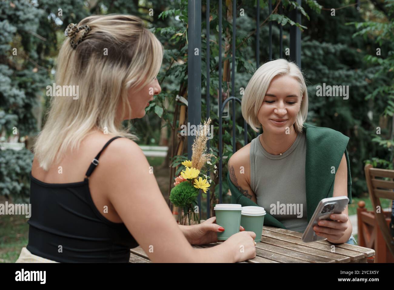 Two friends enjoying coffee together at an outdoor cafe Stock Photo - Alamy