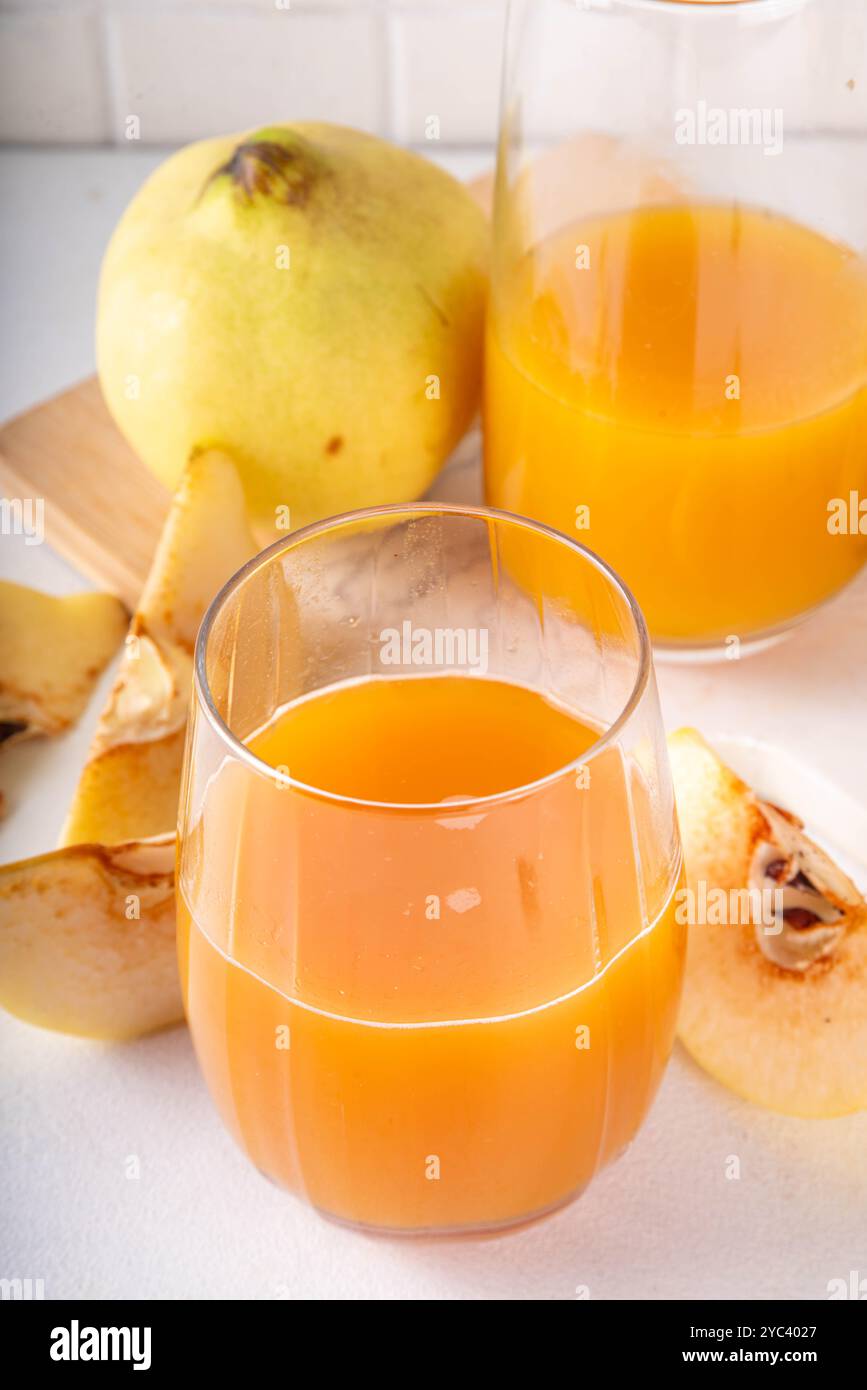 Fresh homemade apple quince juice in portioned glasses, with whole and ...
