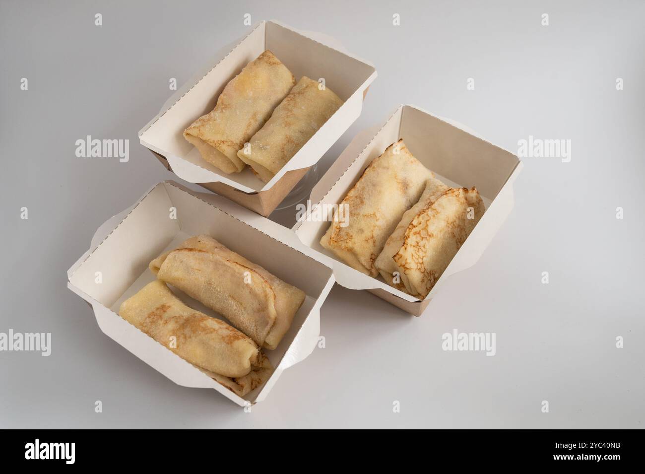 Three takeout boxes filled with neatly folded crepes, ready for ...