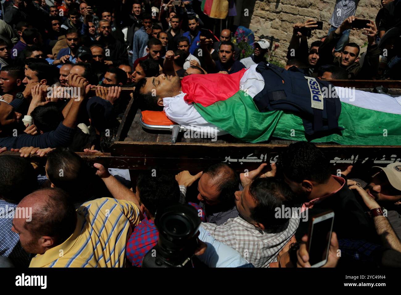 A large crowd and several journalists attend the funeral of their late ...