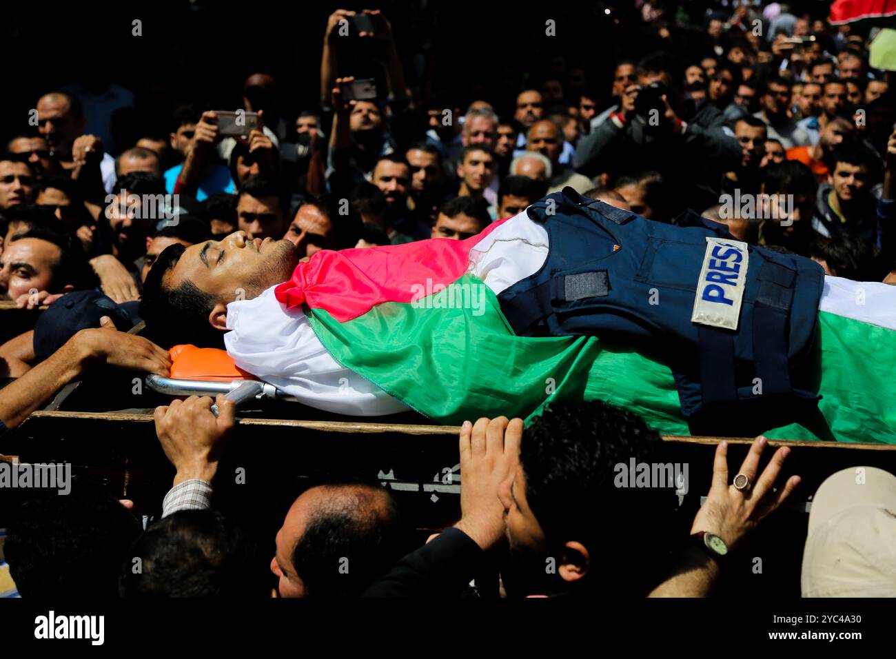 A large crowd and several journalists attend the funeral of their late ...