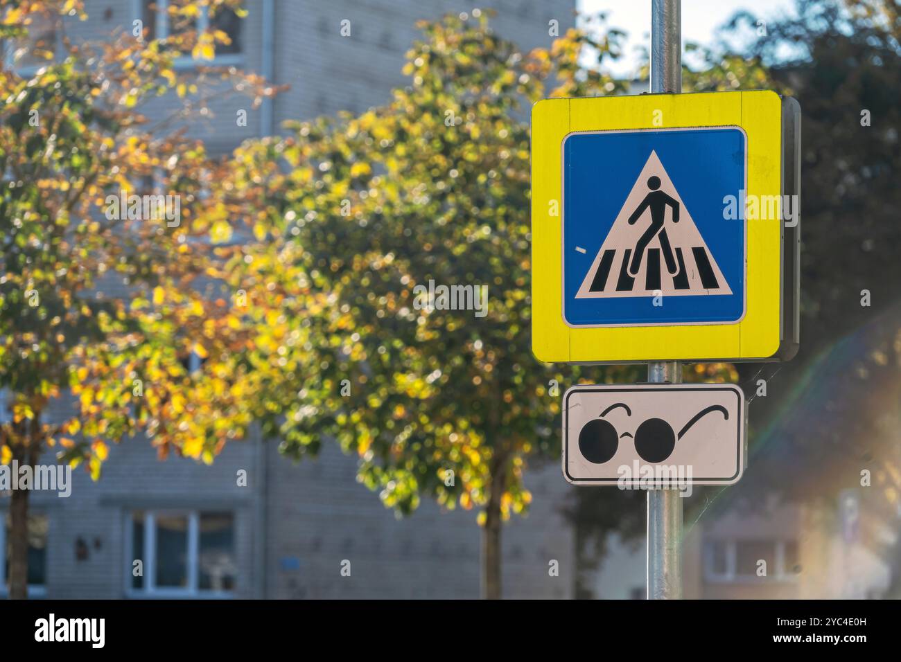 A bright yellow pedestrian crossing sign is visible near sunglasses ...