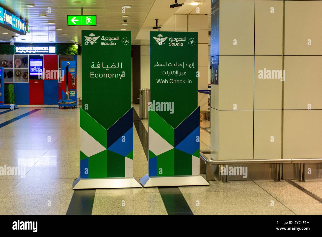 Two green and blue "Economy" and "Web Check-in" signs for Saudia ...