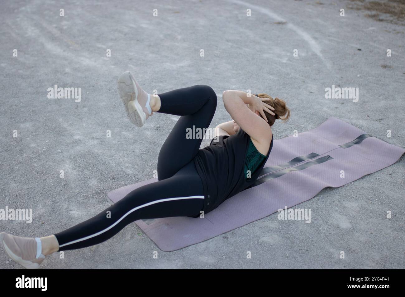 Young woman is improving her abdominal muscles by doing crunches on a ...