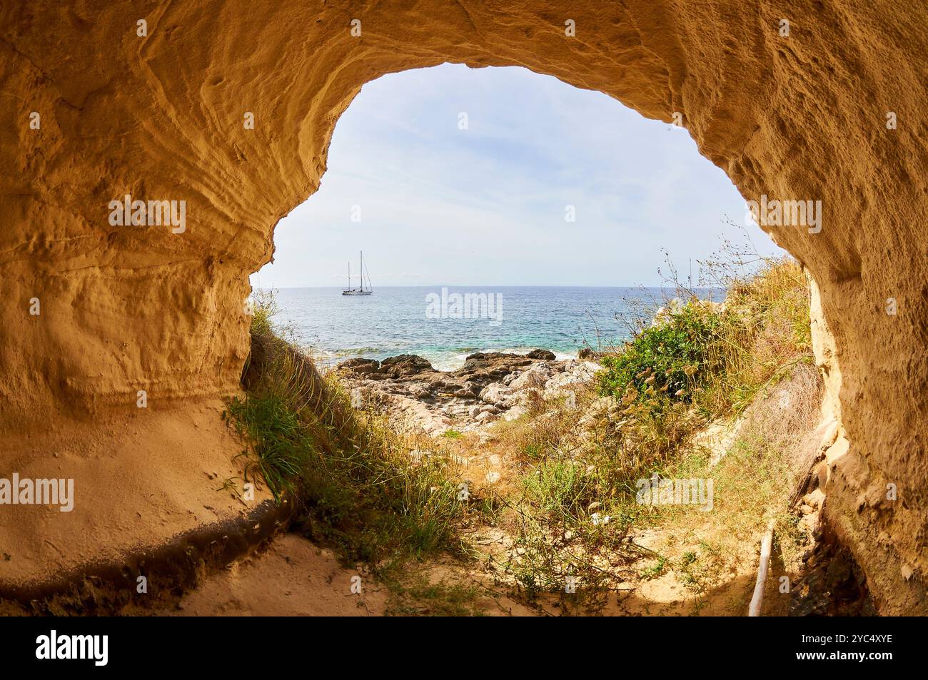 Antique dry dock carved in sandstone at Sa Cala beach and sailing ship ...