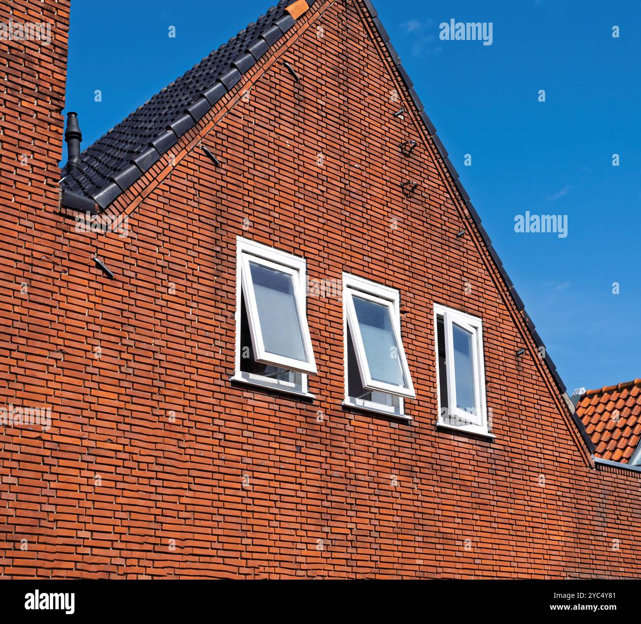 A close-up view of a traditional brick house with triangular gable and ...