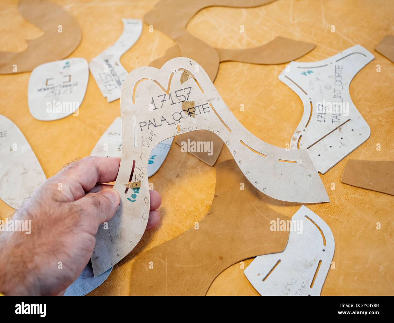 Palma, Spain - Jul 5, 2024: A hand holding a cut-out leather shoe ...