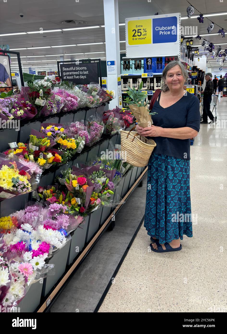 Woman female shopper buying flowers at plant stall in Tesco superstore ...