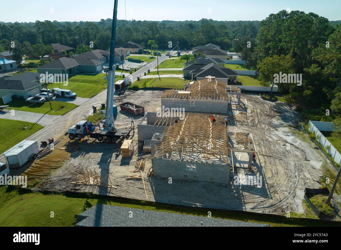 Aerial view of lifting crane and builders working on unfinished ...