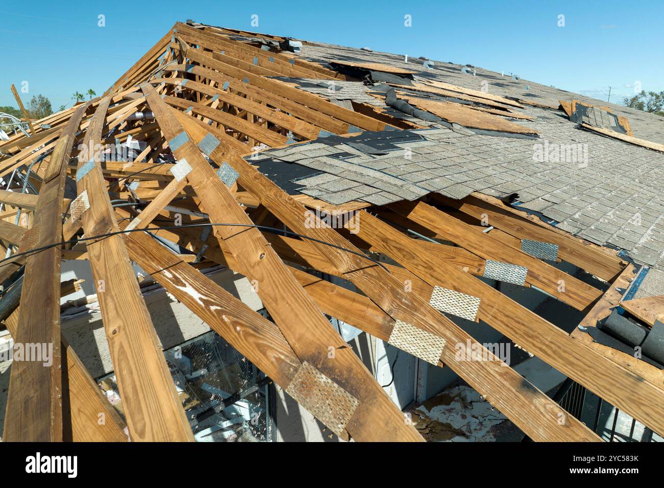 Wind damaged house roof with missing asphalt shingles after hurricane ...