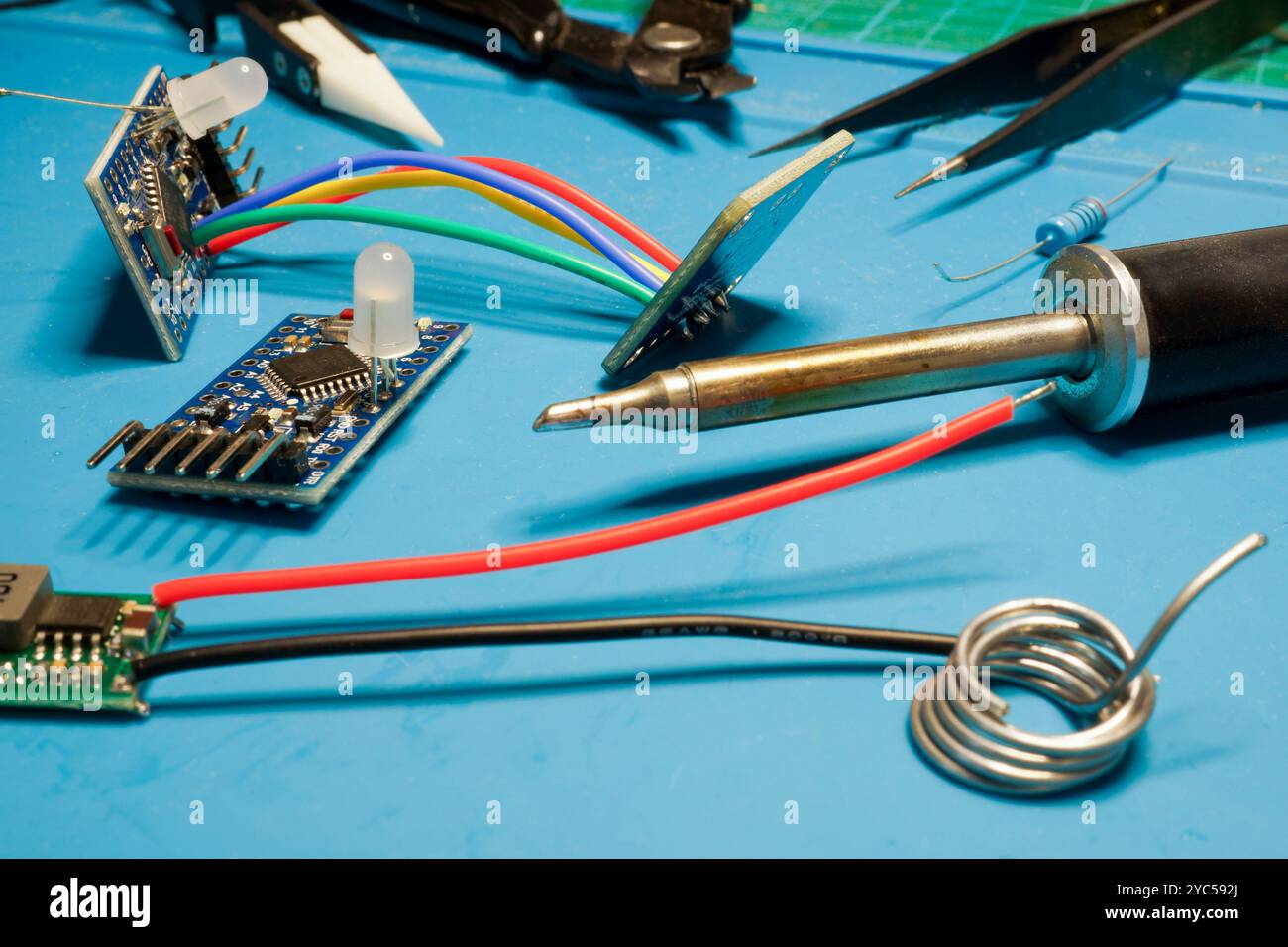 Close-up of a workspace with soldering iron, schematics and wires ...