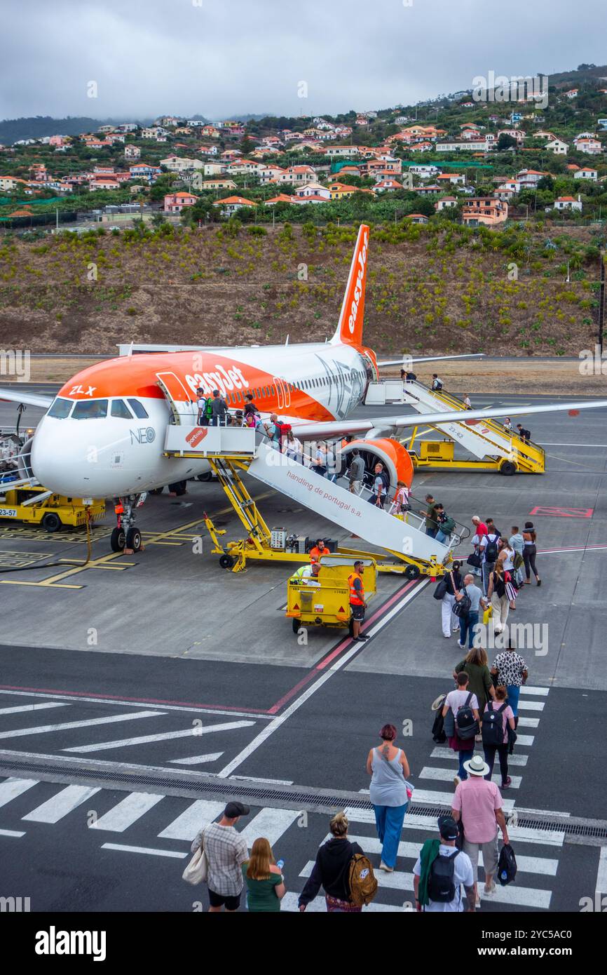 Holidaymakers embarking and disembarking from EasyJet airplane at ...
