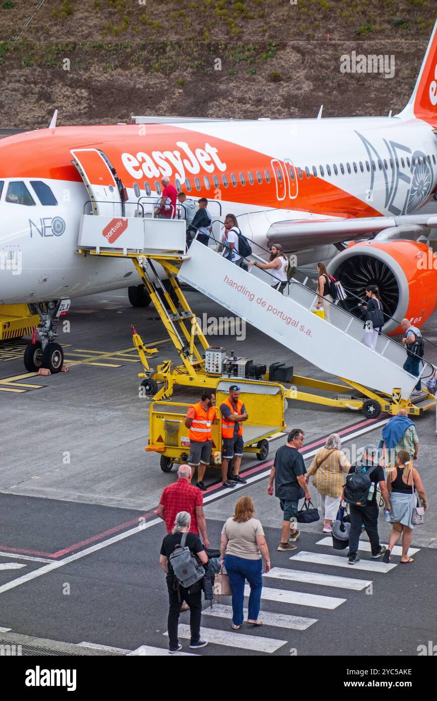 Holidaymakers embarking and disembarking from EasyJet airplane at ...