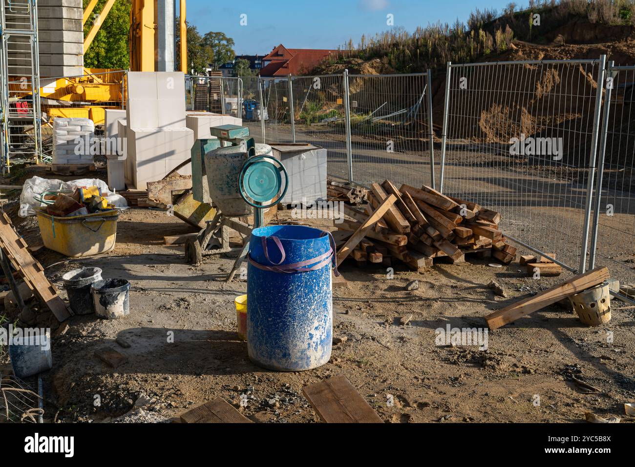 Construction materials and tools are scattered around an active site ...