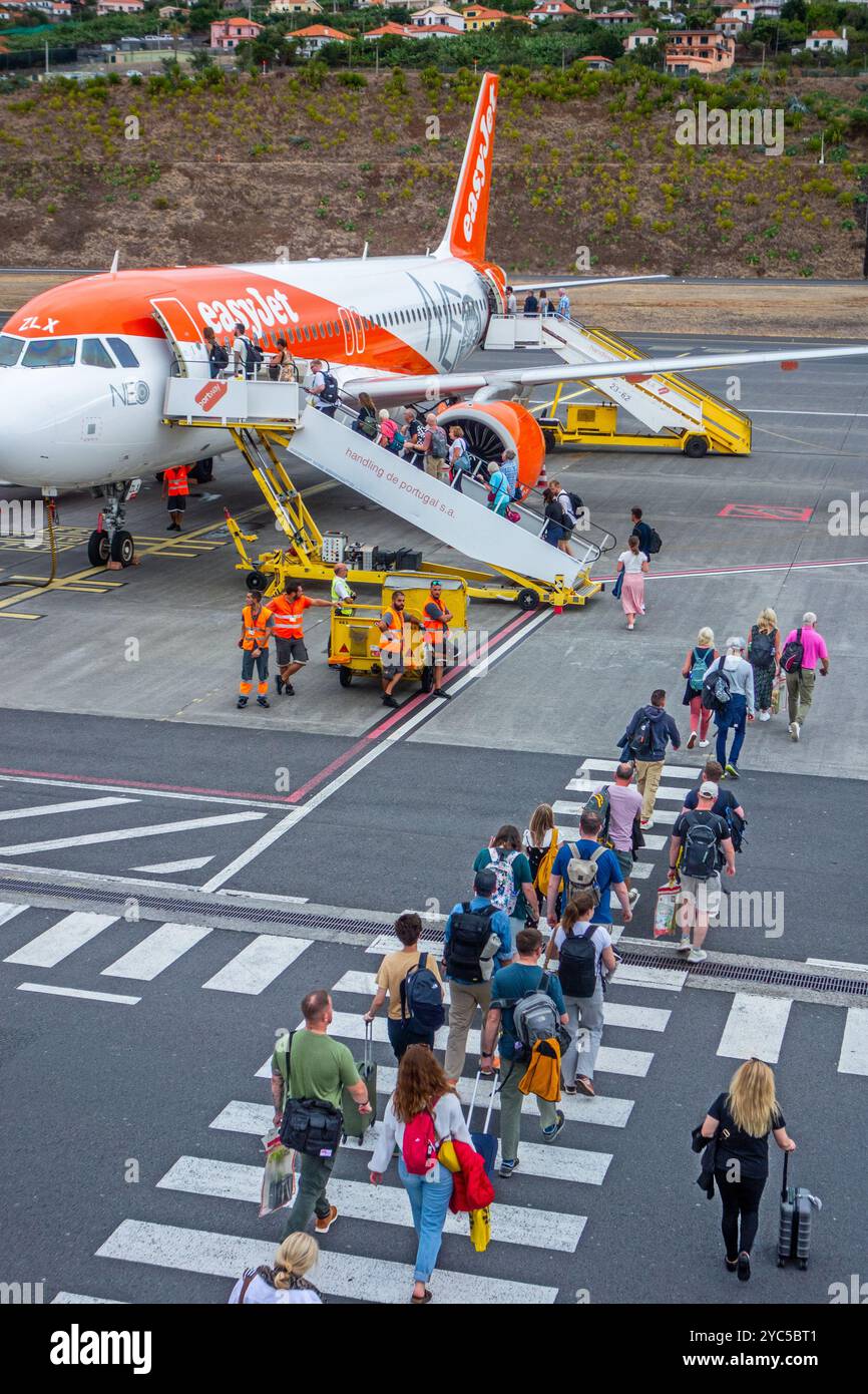 Holidaymakers embarking and disembarking from EasyJet airplane at ...