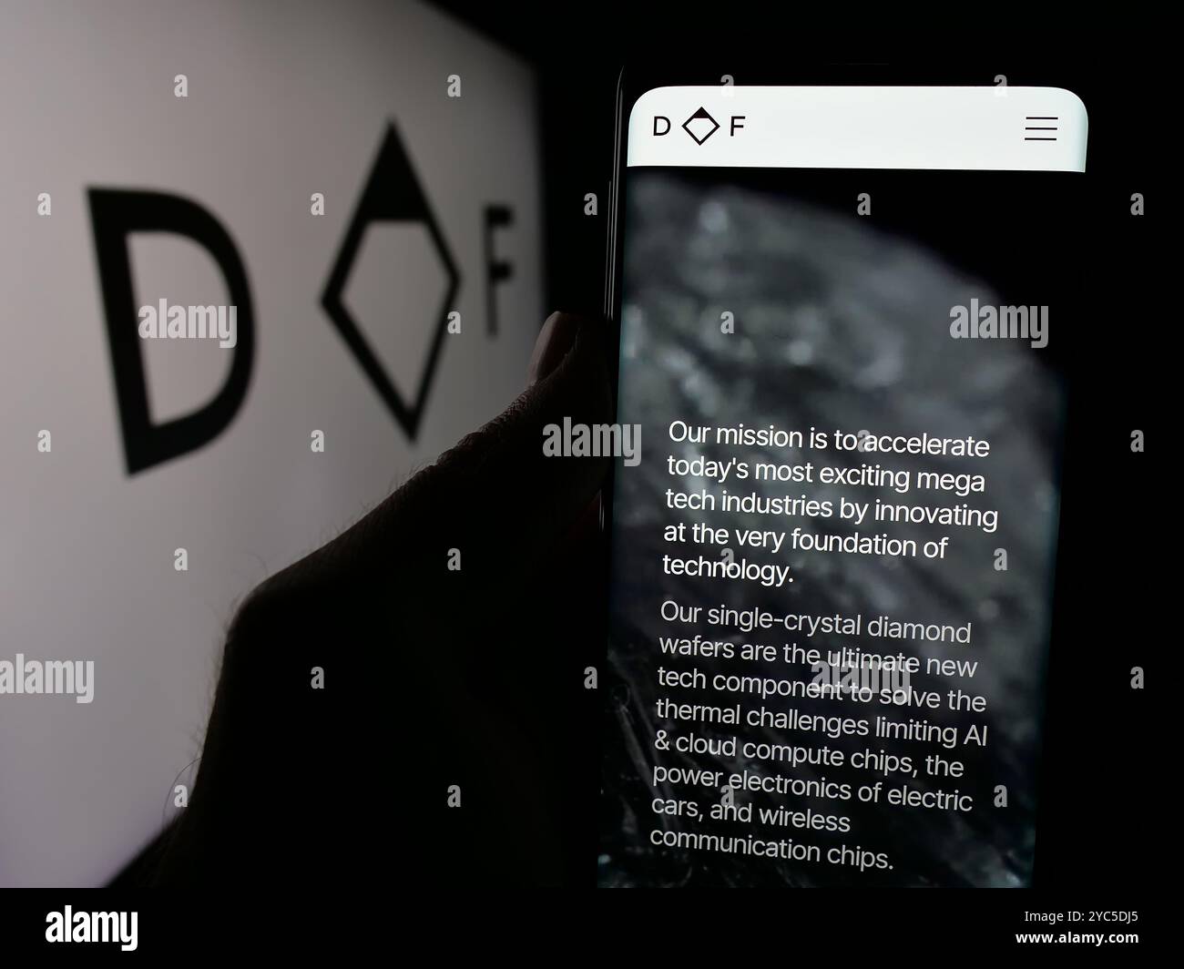Person holding smartphone with webpage of US diamonds company Diamond ...