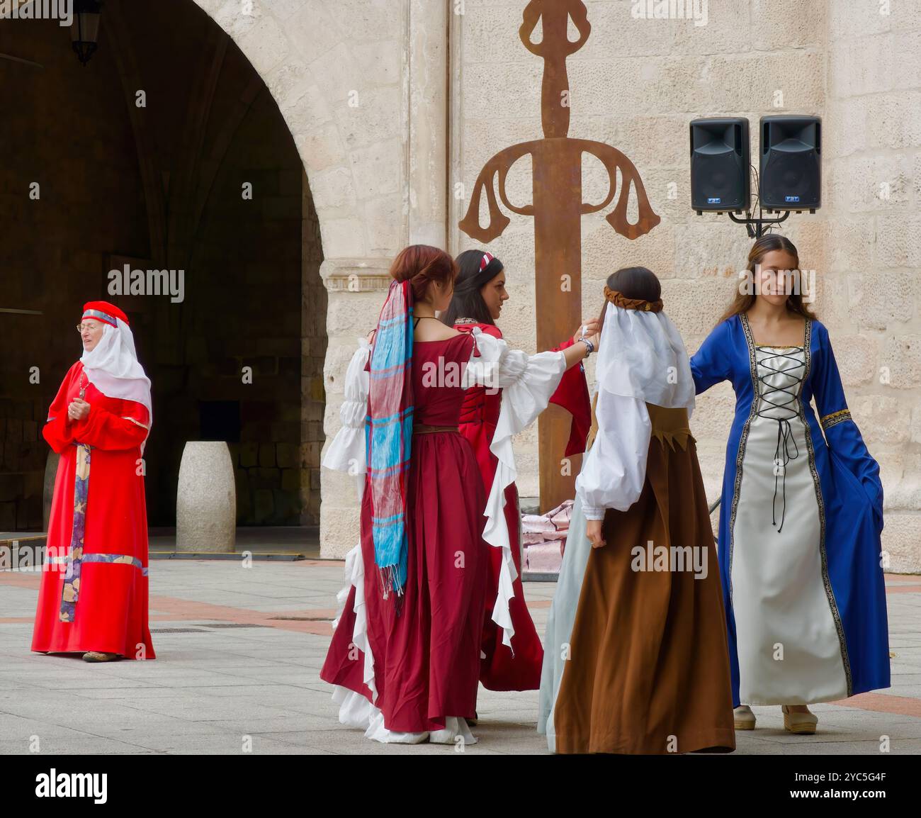 Girls in traditional costumes dancing in front of the Arco de Santa ...
