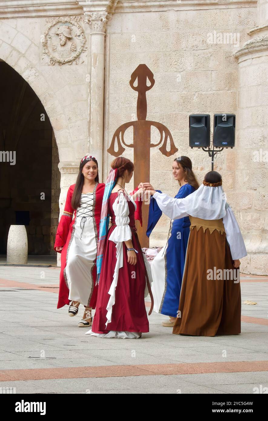 Girls in traditional costumes dancing in front of the Arco de Santa ...