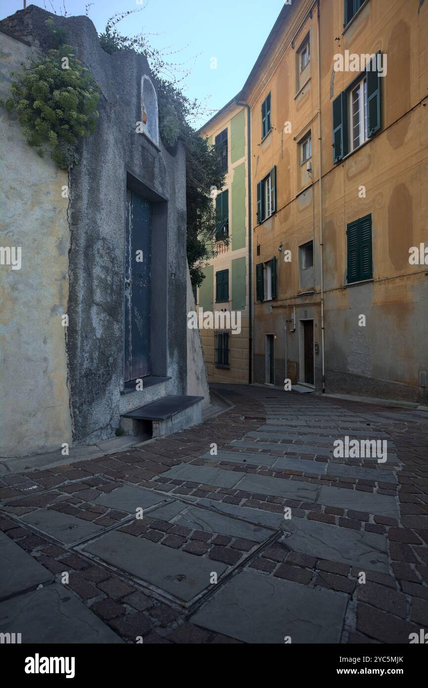 Bend in a cobbled alley between tall buildings in an italian town Stock ...