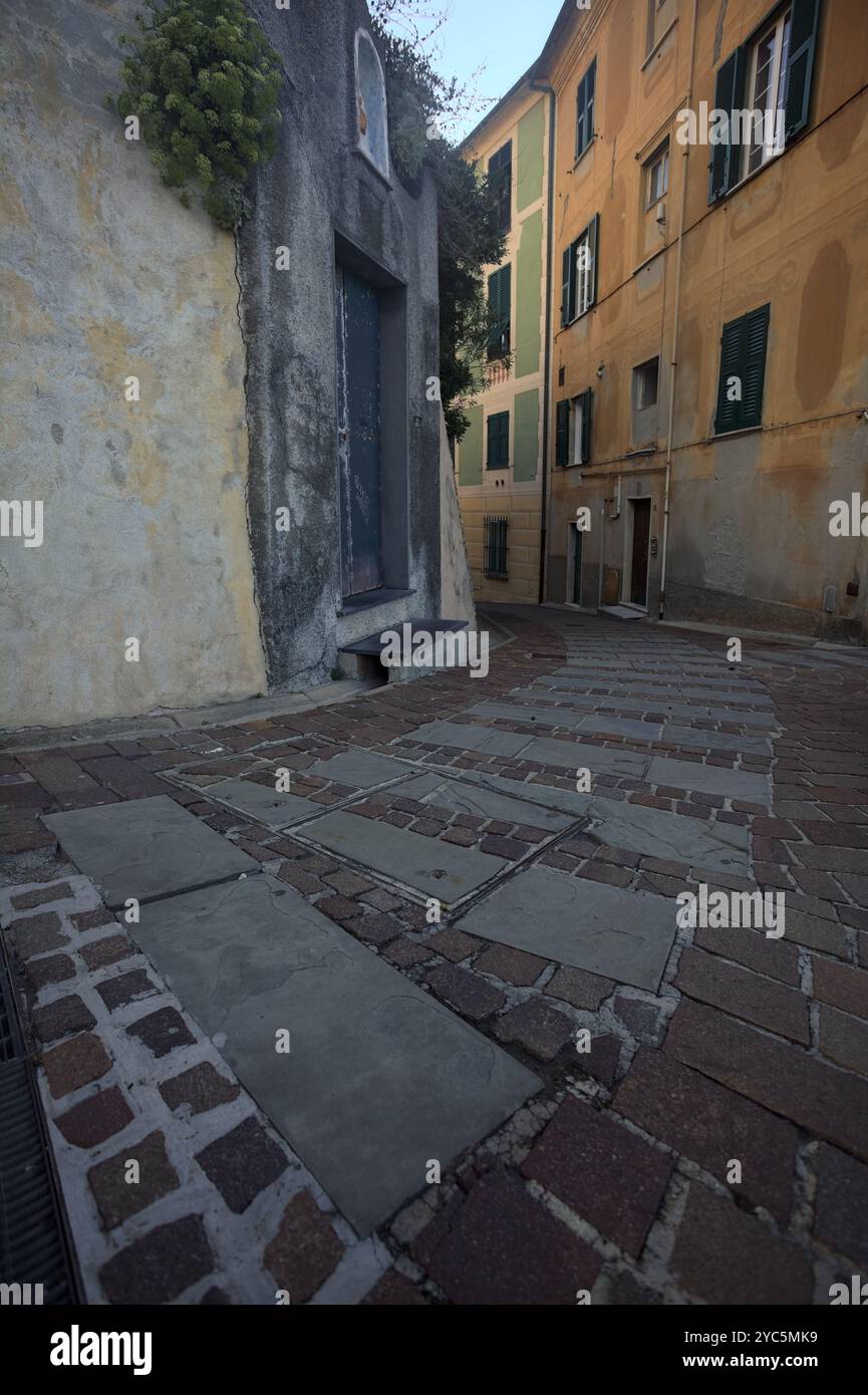 Bend in a cobbled alley between tall buildings in an italian town Stock ...