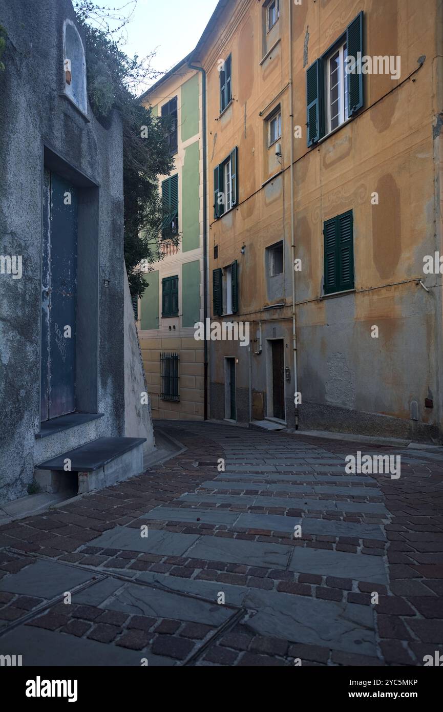 Bend in a cobbled alley between tall buildings in an italian town Stock ...