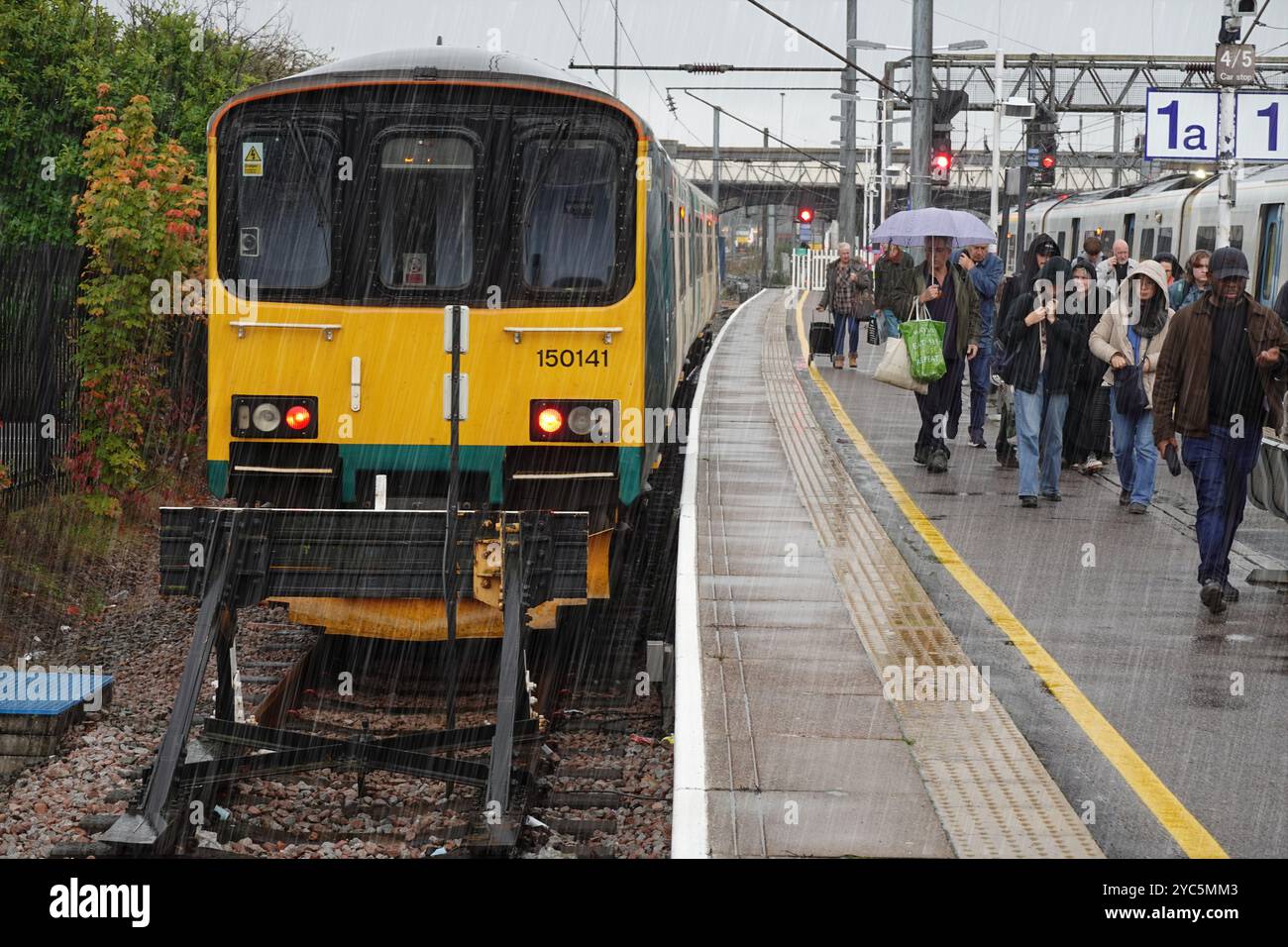 Passengers getting off train in heavy rain at platform 1A in Bedford ...