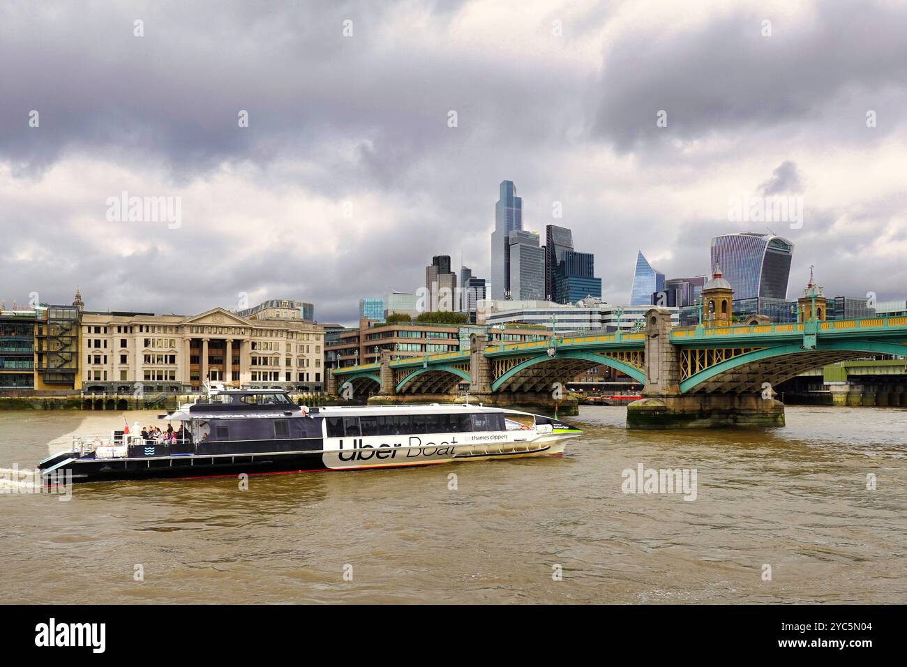 Uber Boat by Thames Clippers passing under Southwark Bridge on River ...
