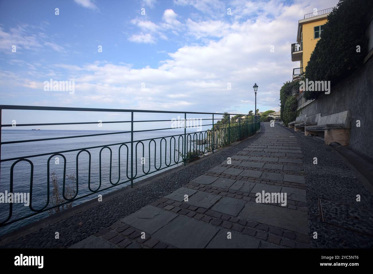 Promenade by the sea bordered by boundary wall of houses in the morning ...