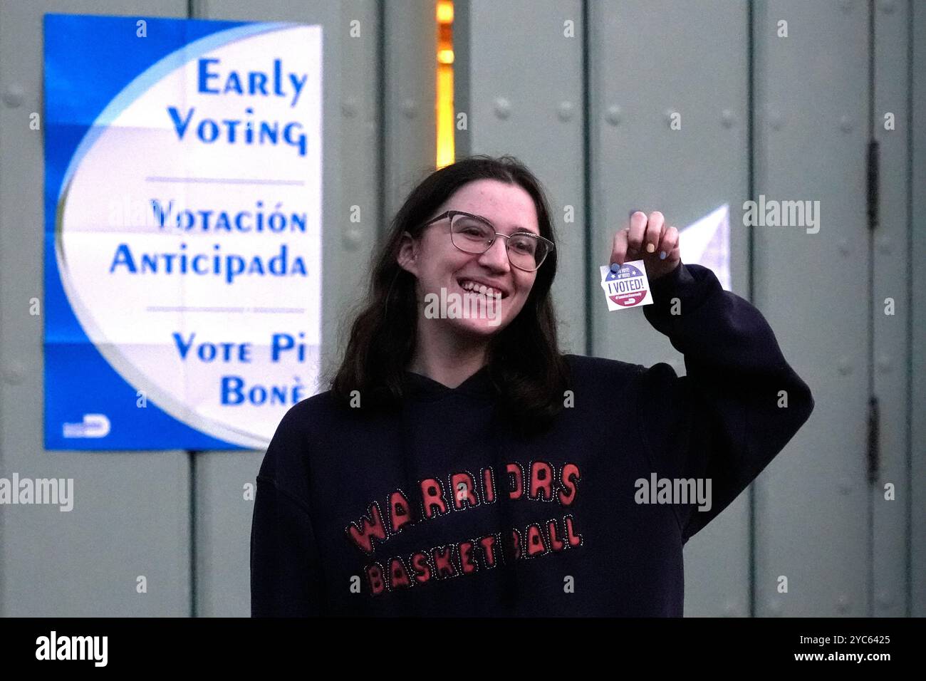 Ashley Herman holds up a sticker after voting on the first day of early ...