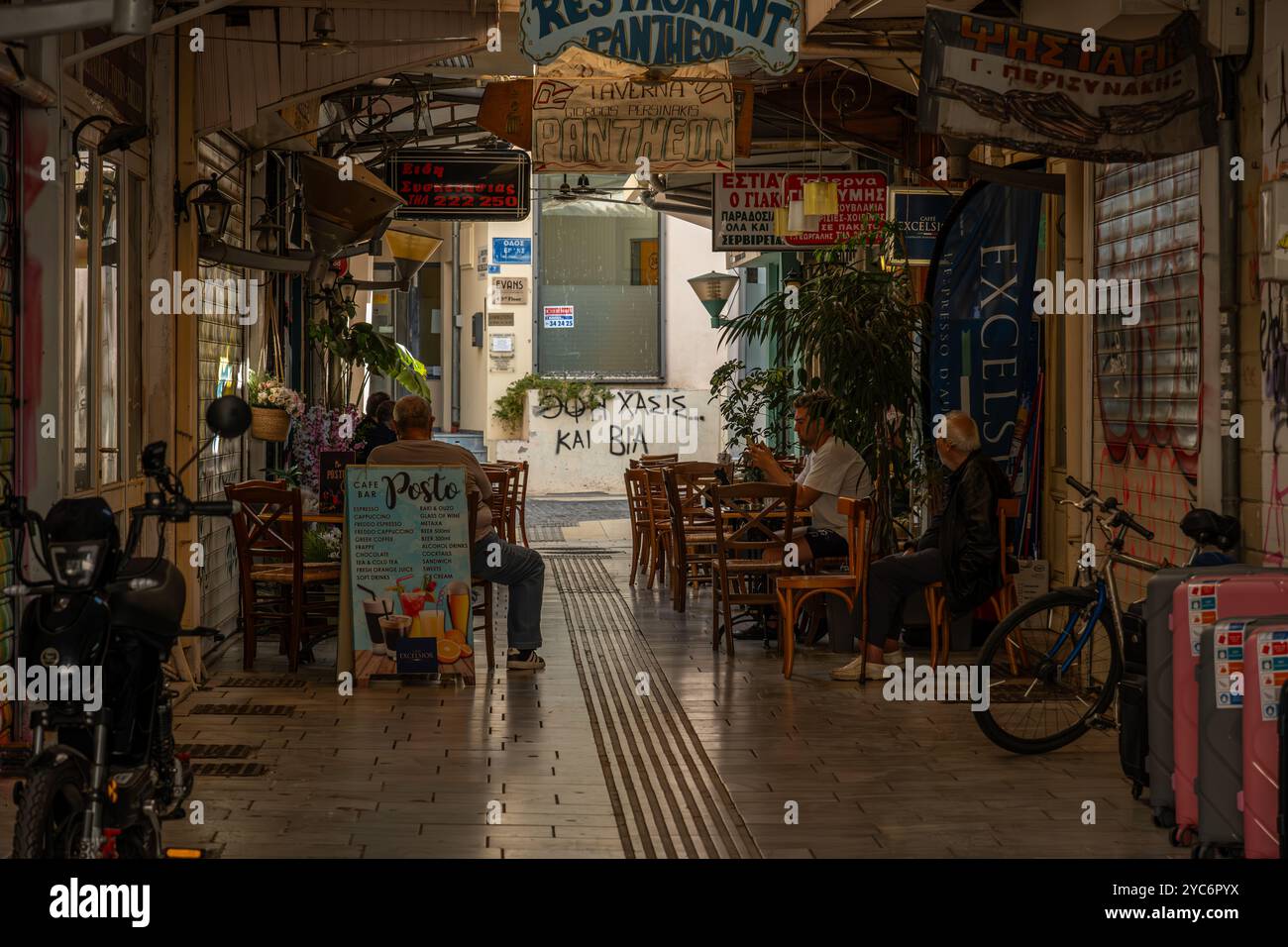 Covered street in Greece with cafés and signage, typical Mediterranean ...