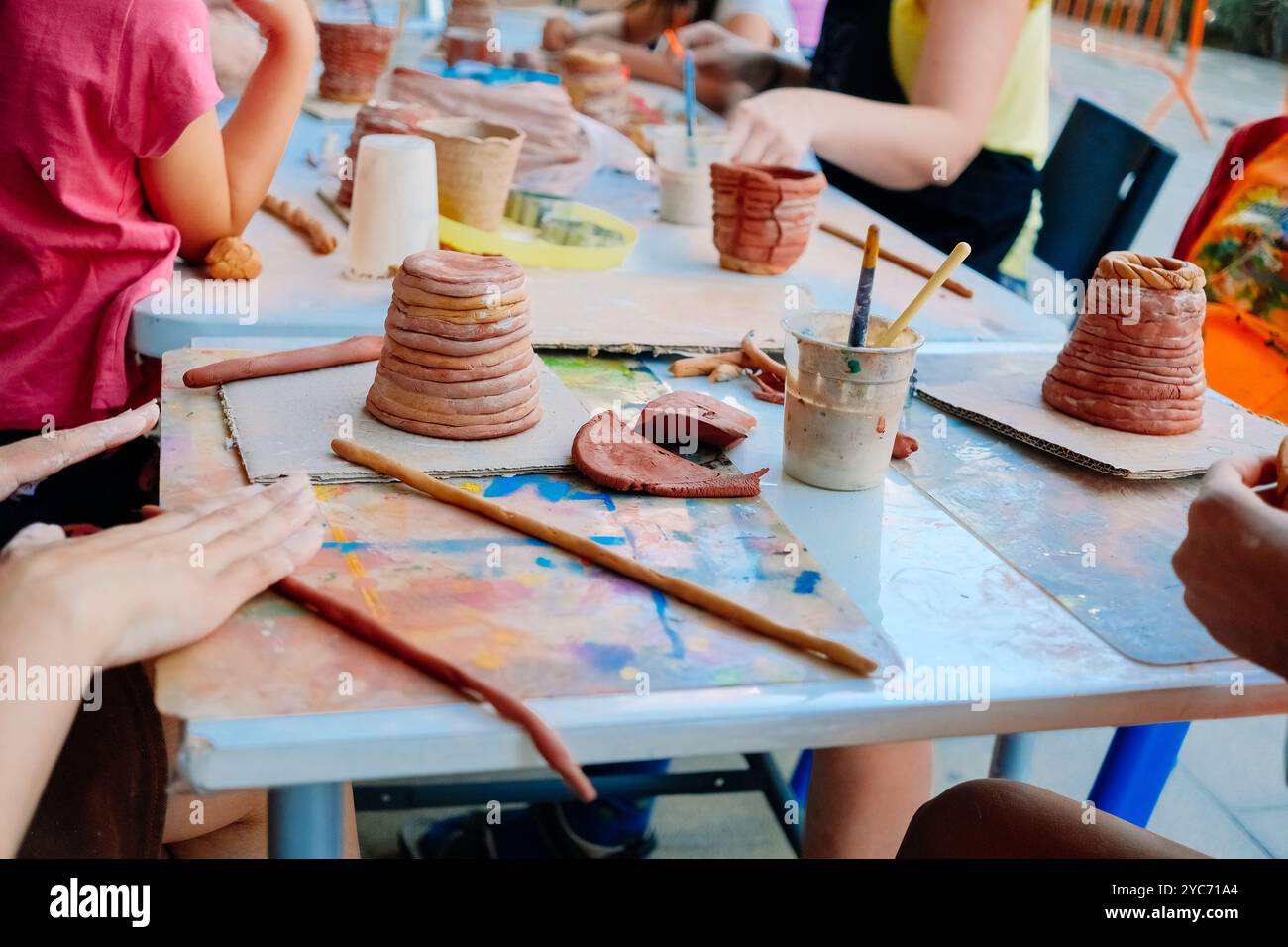 A close-up view of hands manipulating clay pieces in a crafts and ...