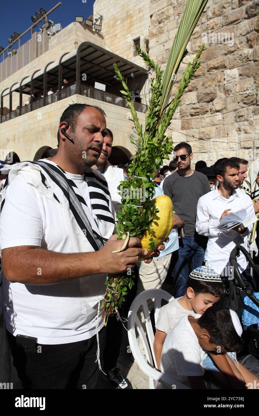 A Jew wearing prayer shawls or Talith prays at the Western Wall while ...