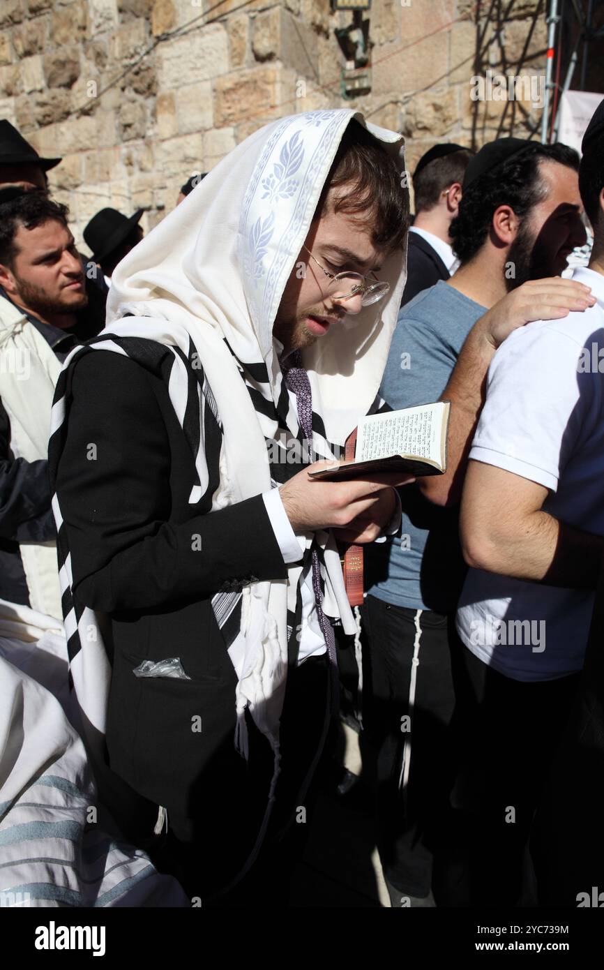 Ultra Orthodox Jew wearing a Talith praying from a prayer book at the ...