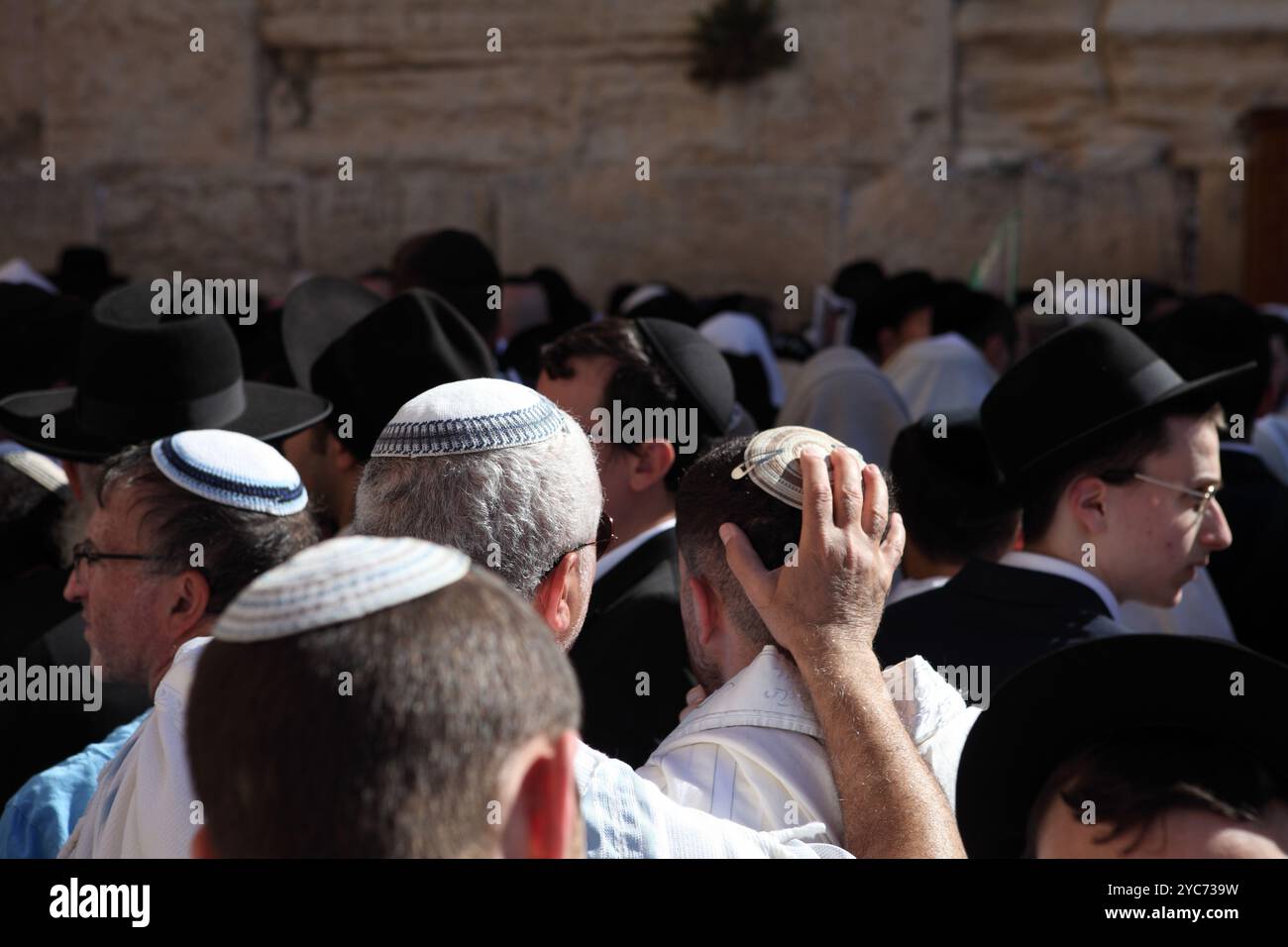 Orthodox Jew puts his hand on his son's head blessing him while praying ...