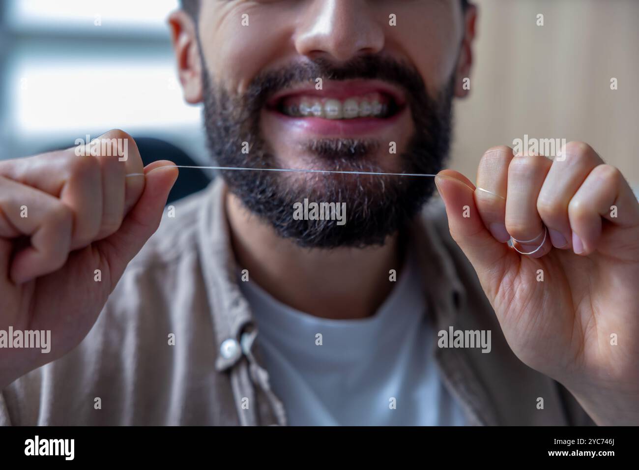 Man holding dental floss following hygiene routine to maintain fresh ...
