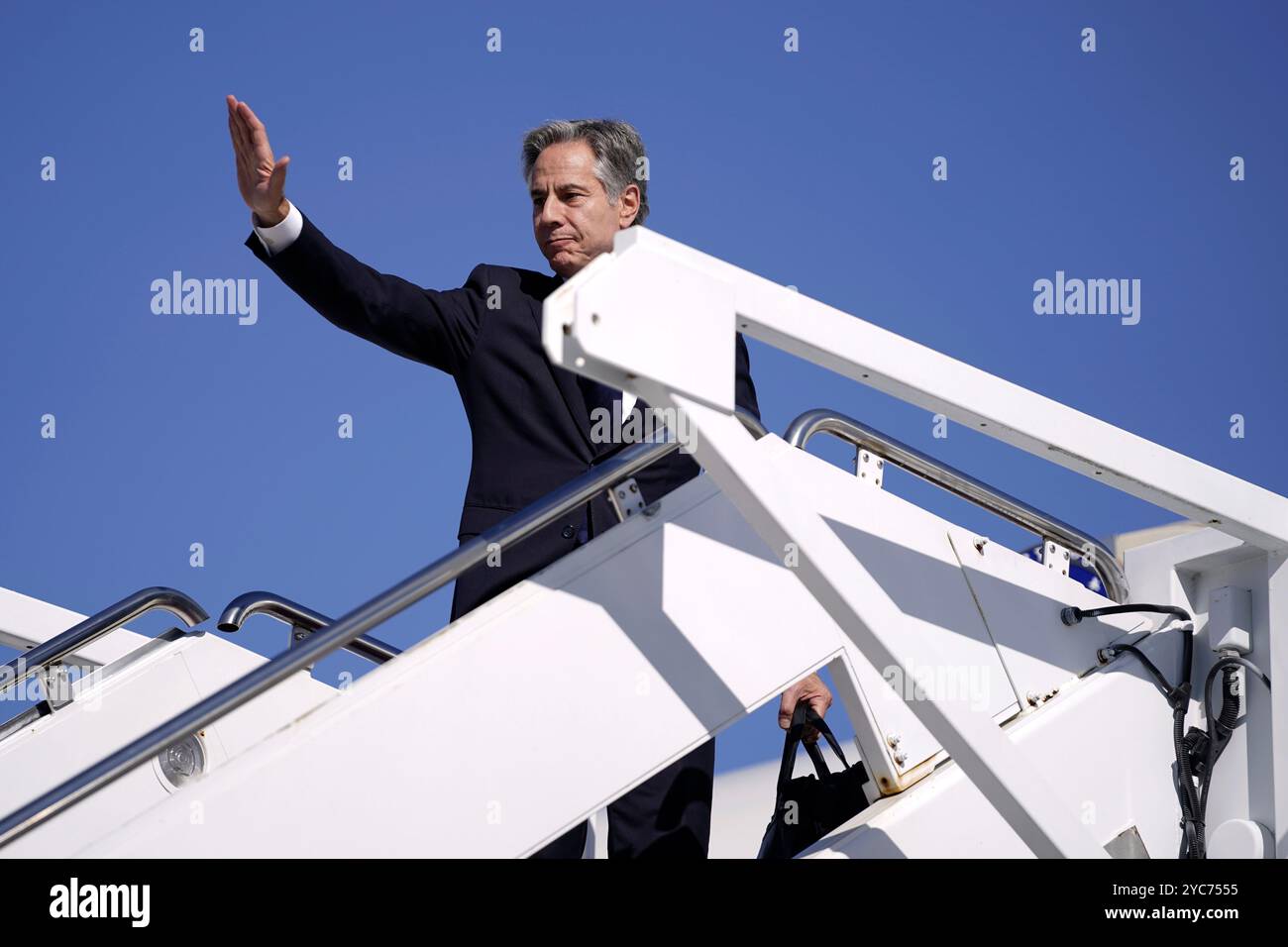 Secretary of State Antony Blinken waves as he boards a plane en route ...