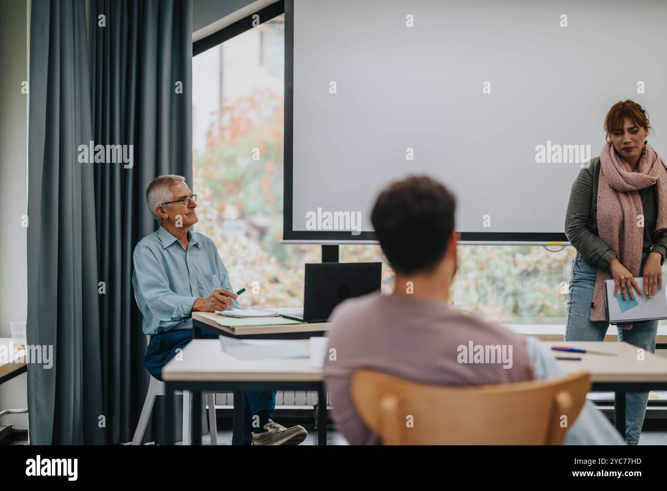 Elderly professor engaging with students in a classroom setting Stock Photo - Alamy