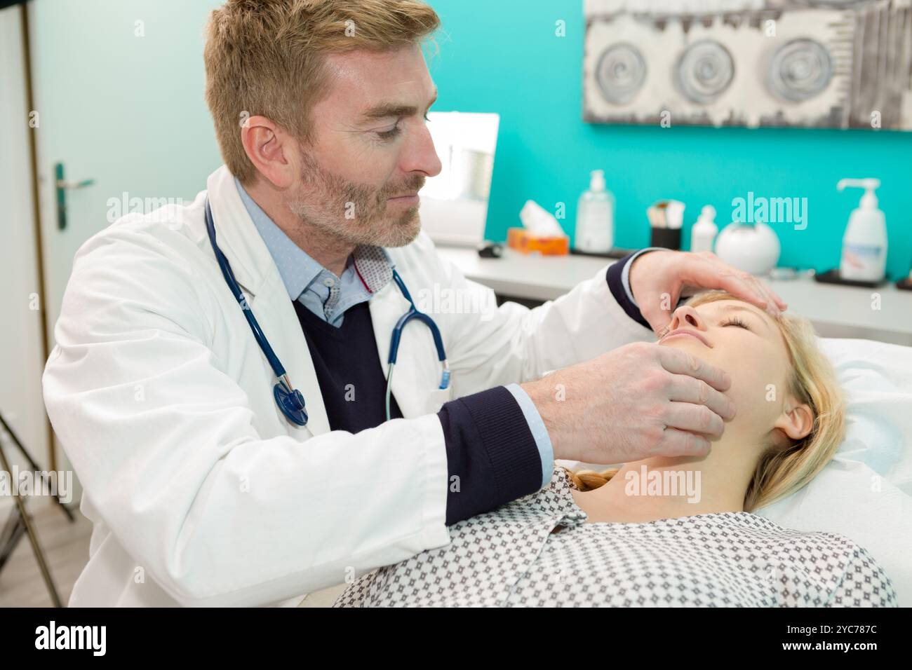 doctor examining young female patients face Stock Photo - Alamy