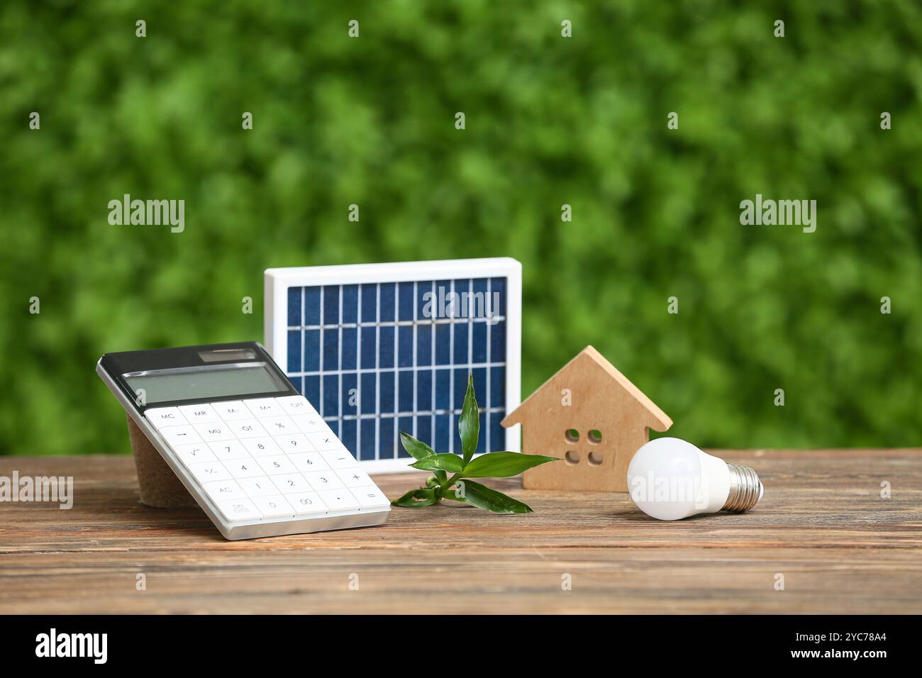 Portable solar panel with house figure, light bulb and calculator on ...