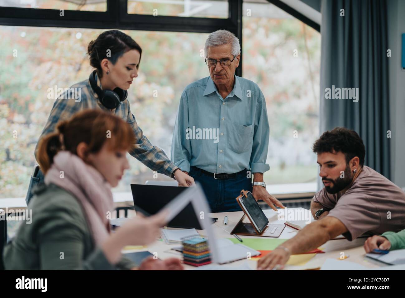 University professor guiding students during collaborative project work Stock Photo - Alamy