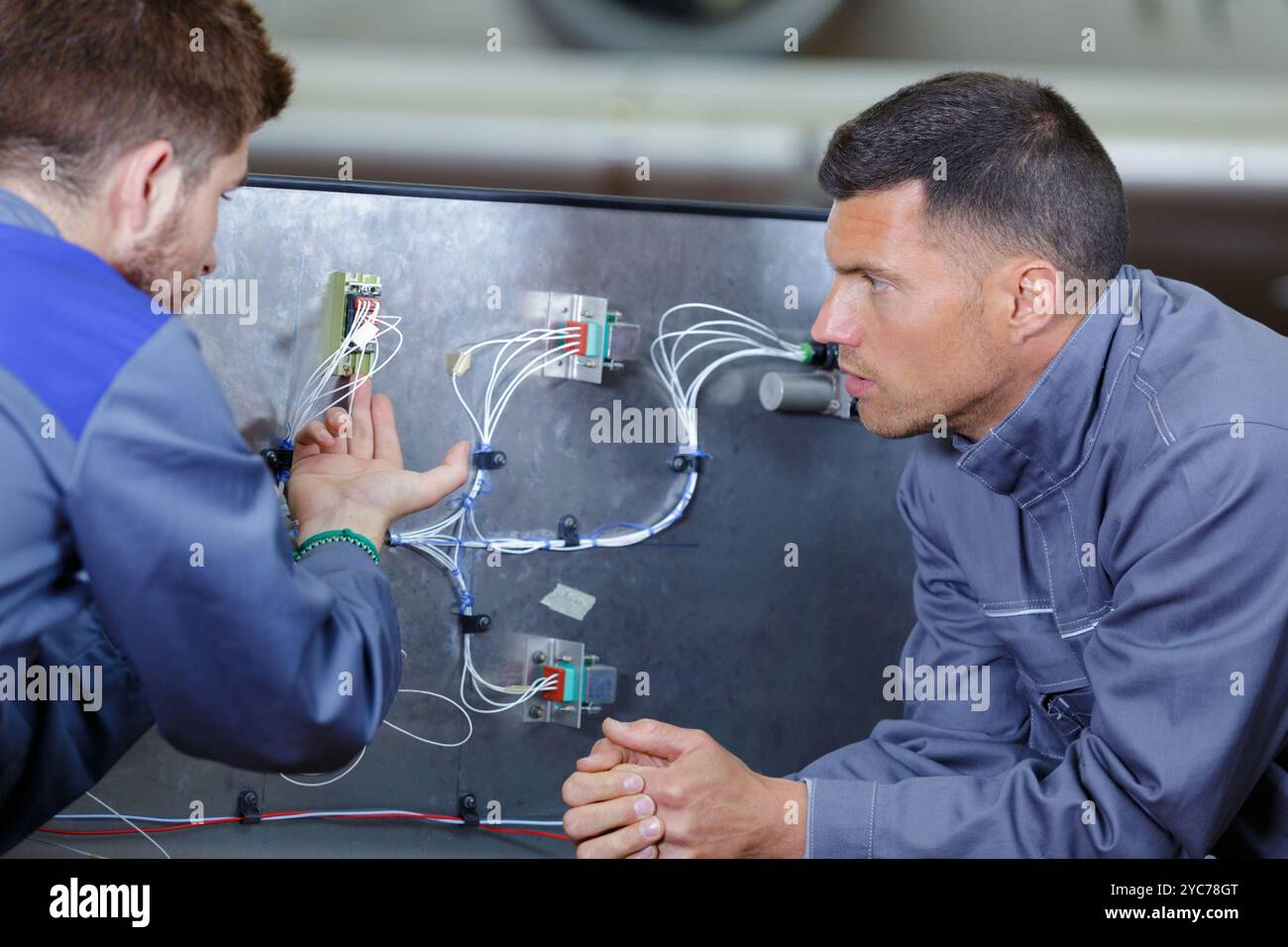 young electrician fixing electrical problems on a pmachine Stock Photo ...