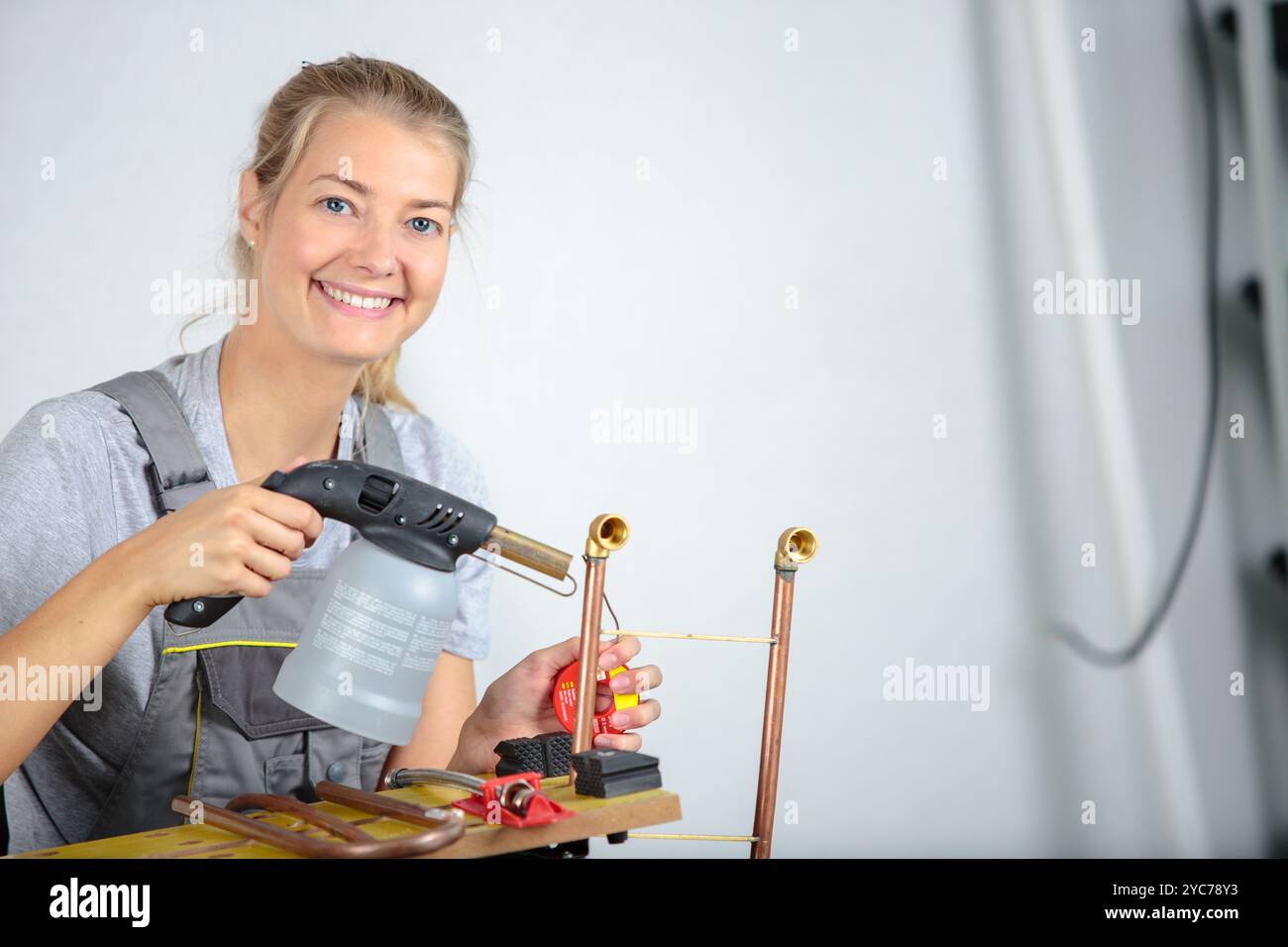 happy woman soldering cooper pipes Stock Photo - Alamy