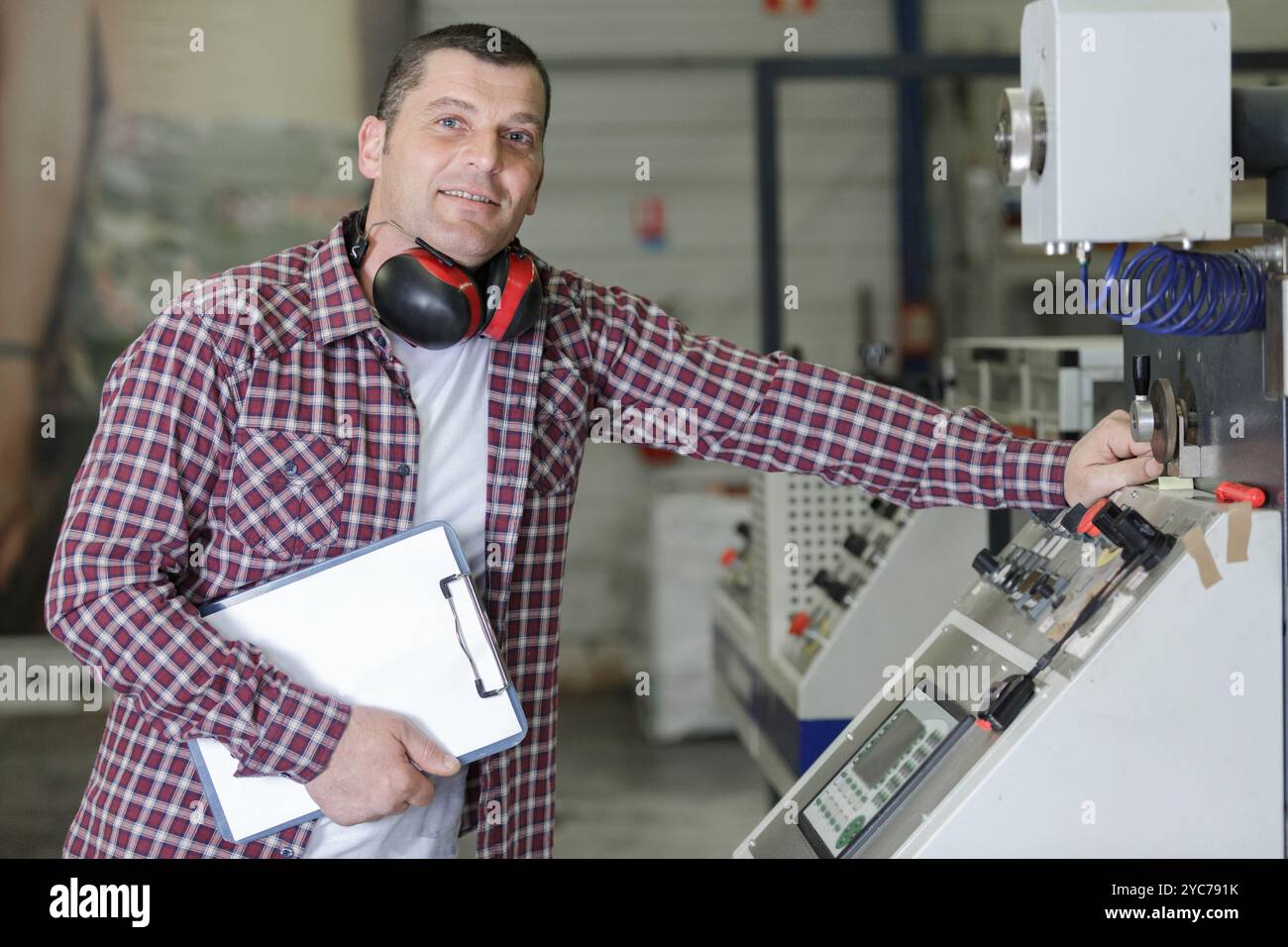 worker with clipboard working on big generator Stock Photo - Alamy