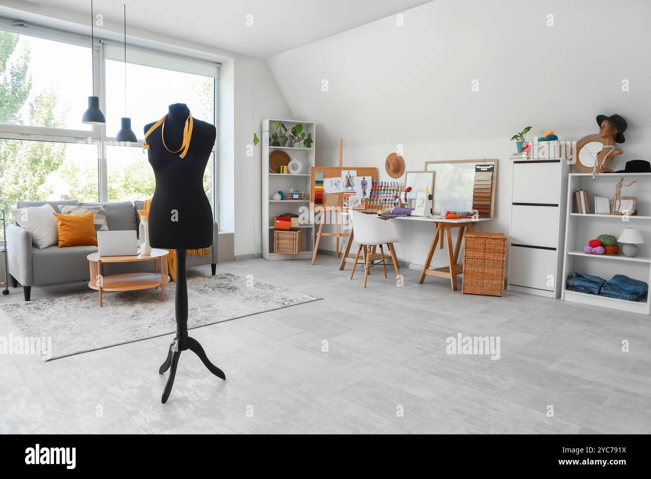 Interior of fashion designer's studio with workplace, sofa and ...