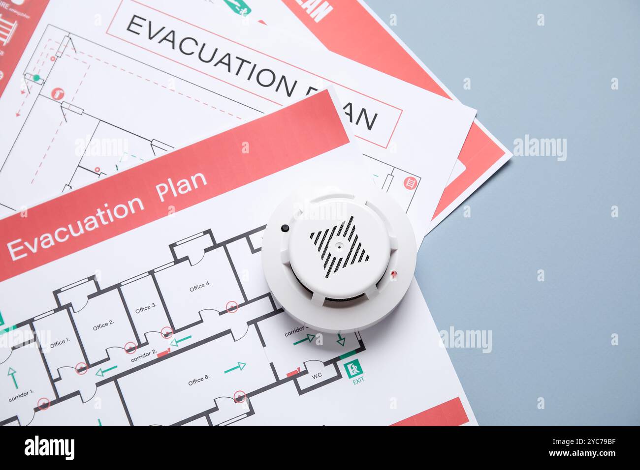 Modern smoke detector with evacuation plans on grey background Stock ...