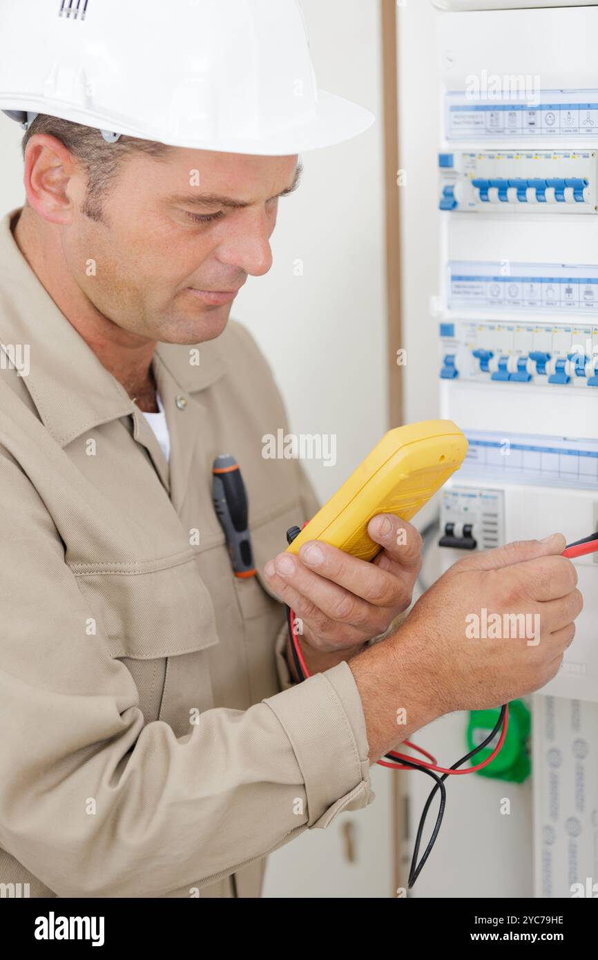 male electrician using multimeter on fusebox Stock Photo - Alamy