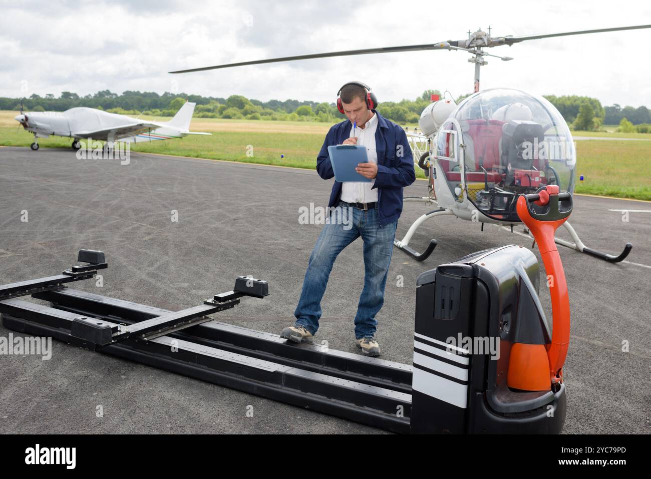 worker with clipboard writing next to helicopter trailer Stock Photo ...
