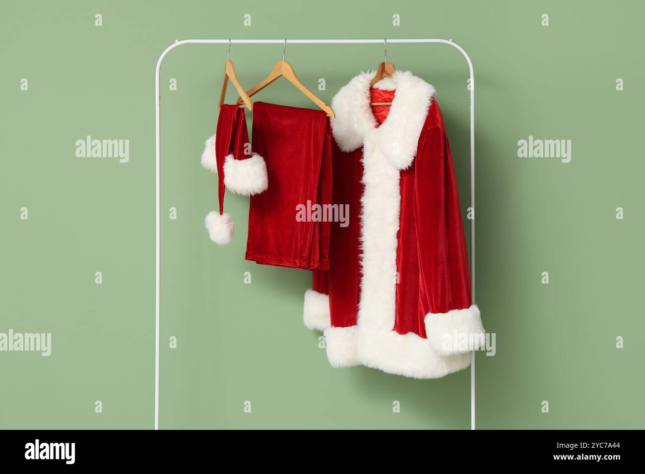 Santa Claus suit hanging on rack near green wall in room Stock Photo ...