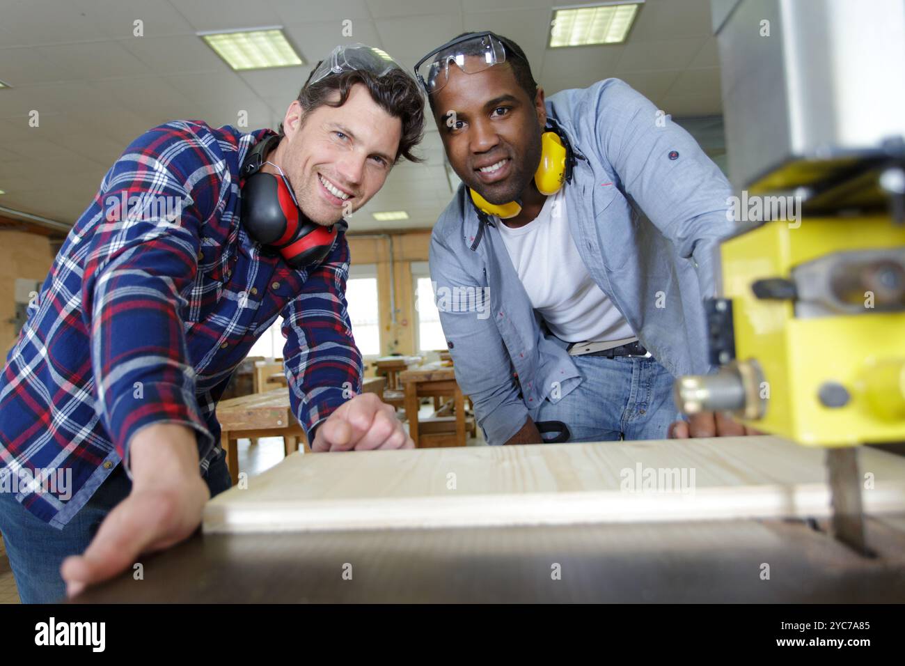male carpenter training apprentice to use plane Stock Photo - Alamy